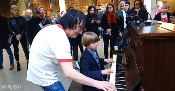 Terry Miles and an 8-year-old boy have fun playing a public piano ...